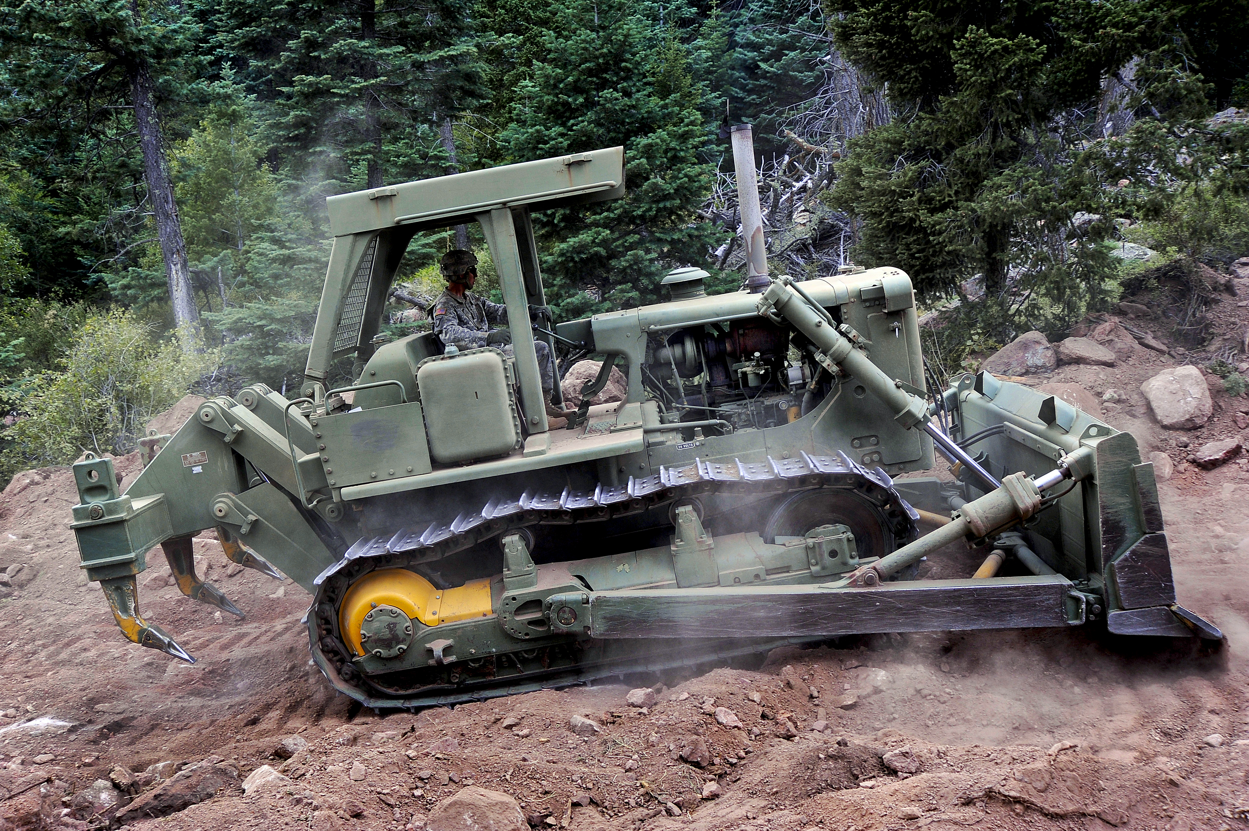 Army Command Sgt. Maj. Ronald G. Patterson builds a firebreak along a ...