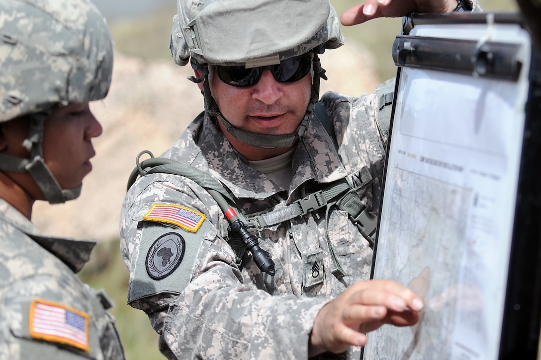 Army Staff Sgt. Jaime Negron, right, explains the terrain features on a ...