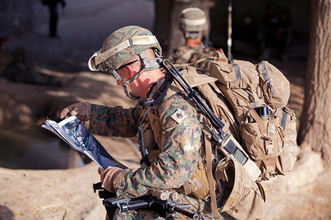 U.S. Marine Corps Staff Sgt. Jeremiah Busetto, front, reads his map ...
