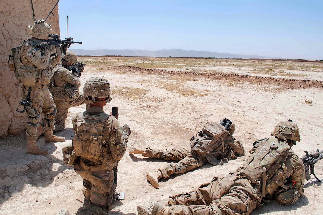U.S. Army Capt. Joseph Driskell, standing, and others engage insurgents ...