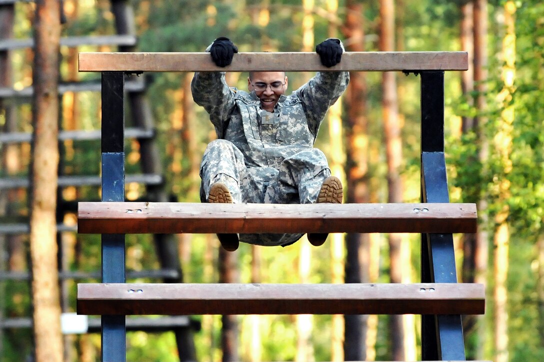 U.S. Army 2nd Lt. Victor Dominguez navigates through an obstacle course ...