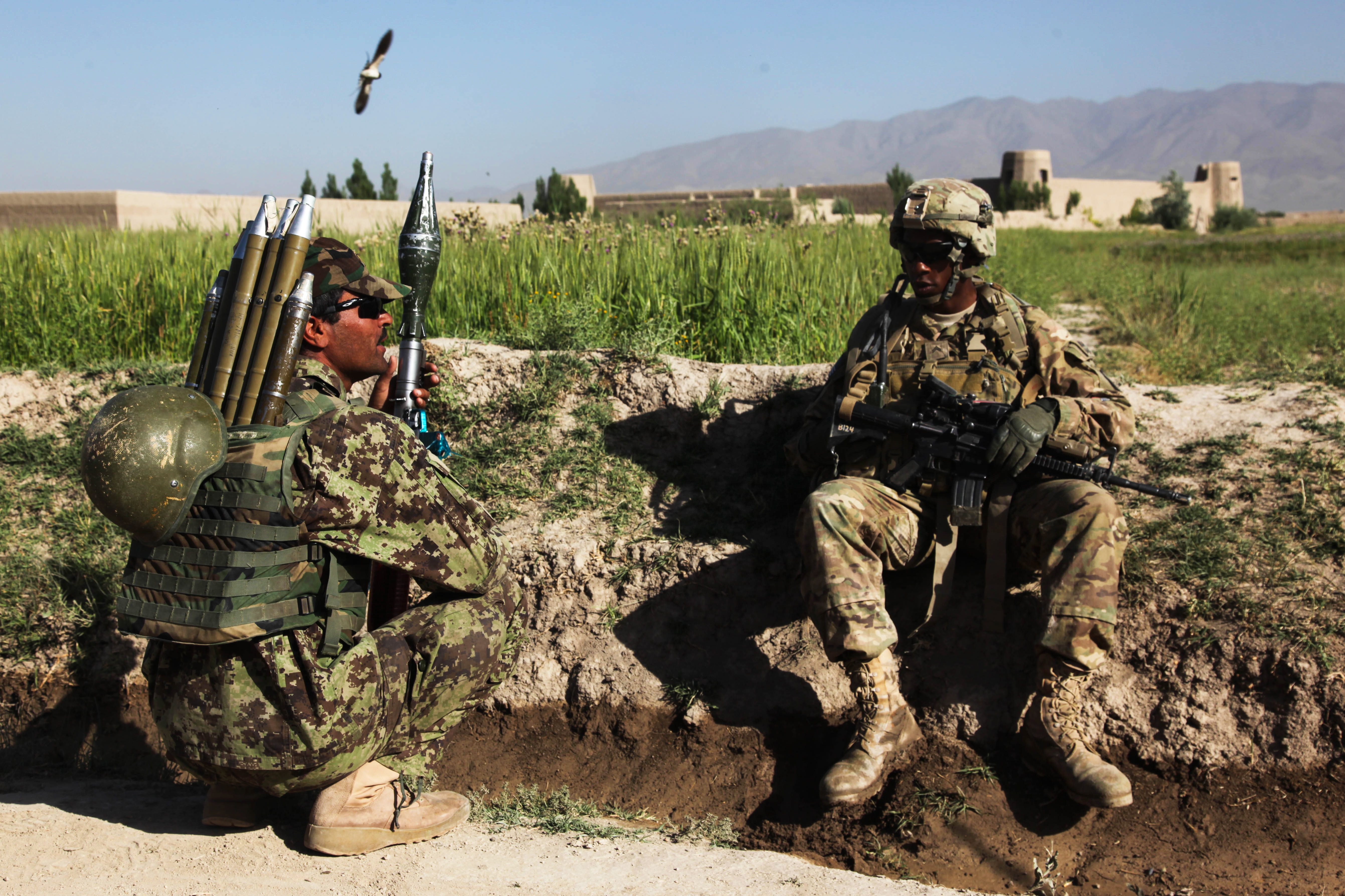 U.S. Army Cpl. Jason Bright, right, and an Afghan soldier sit during a ...