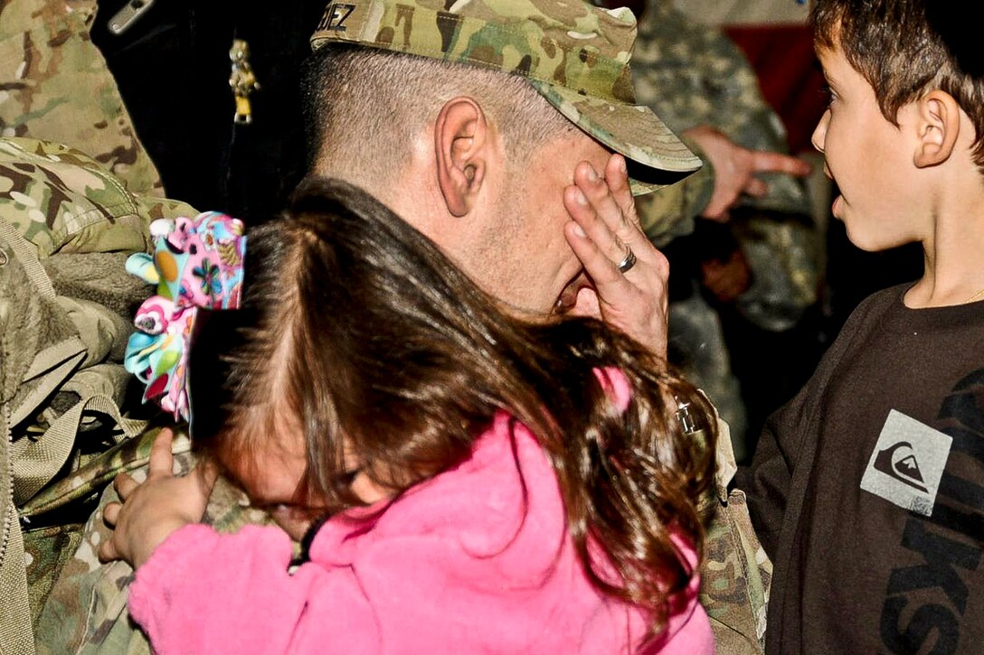 A soldier receives a hug from his daughter on Fort Bragg, N.C., March 1 ...