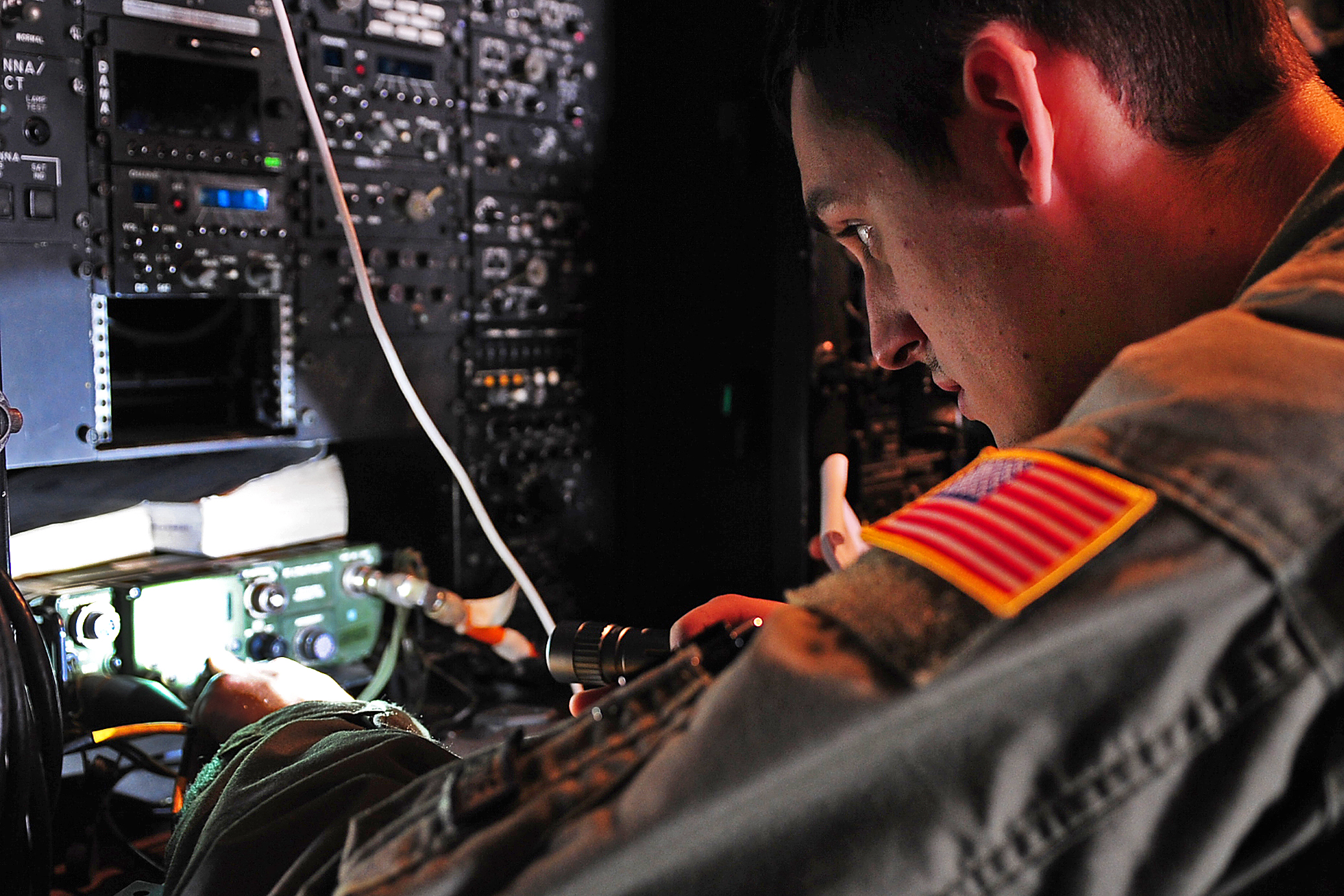 An Air Force aerial communications engineer programs a radio aboard an ...