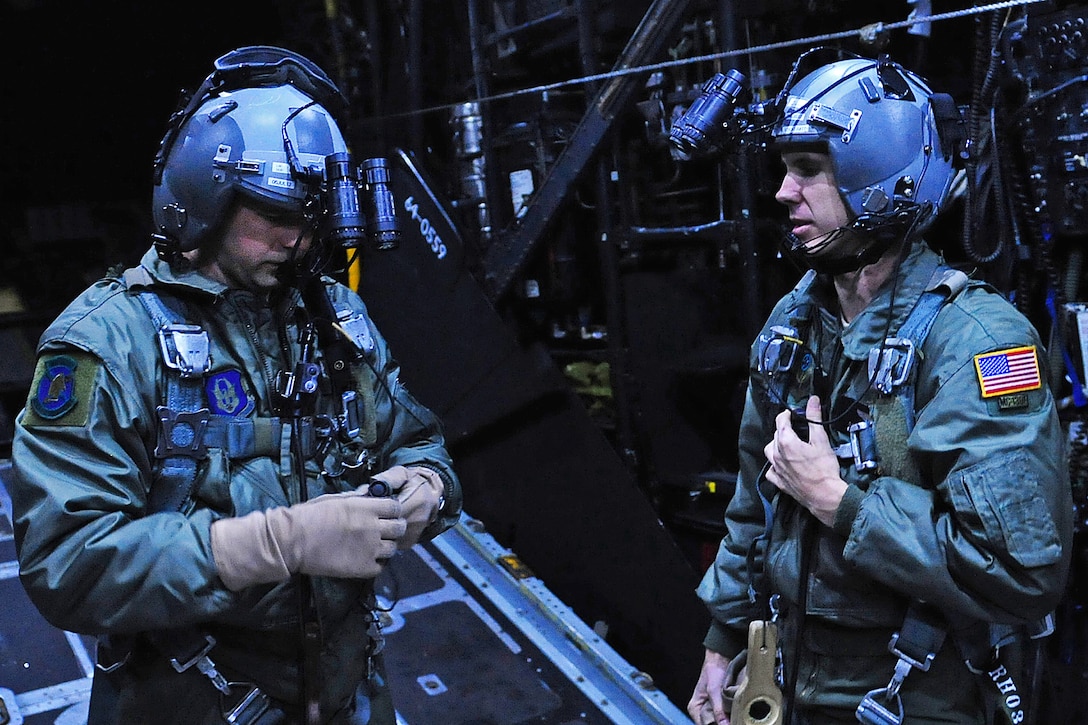 Air Force load masters work aboard a MC-130E aircraft after a aerial ...