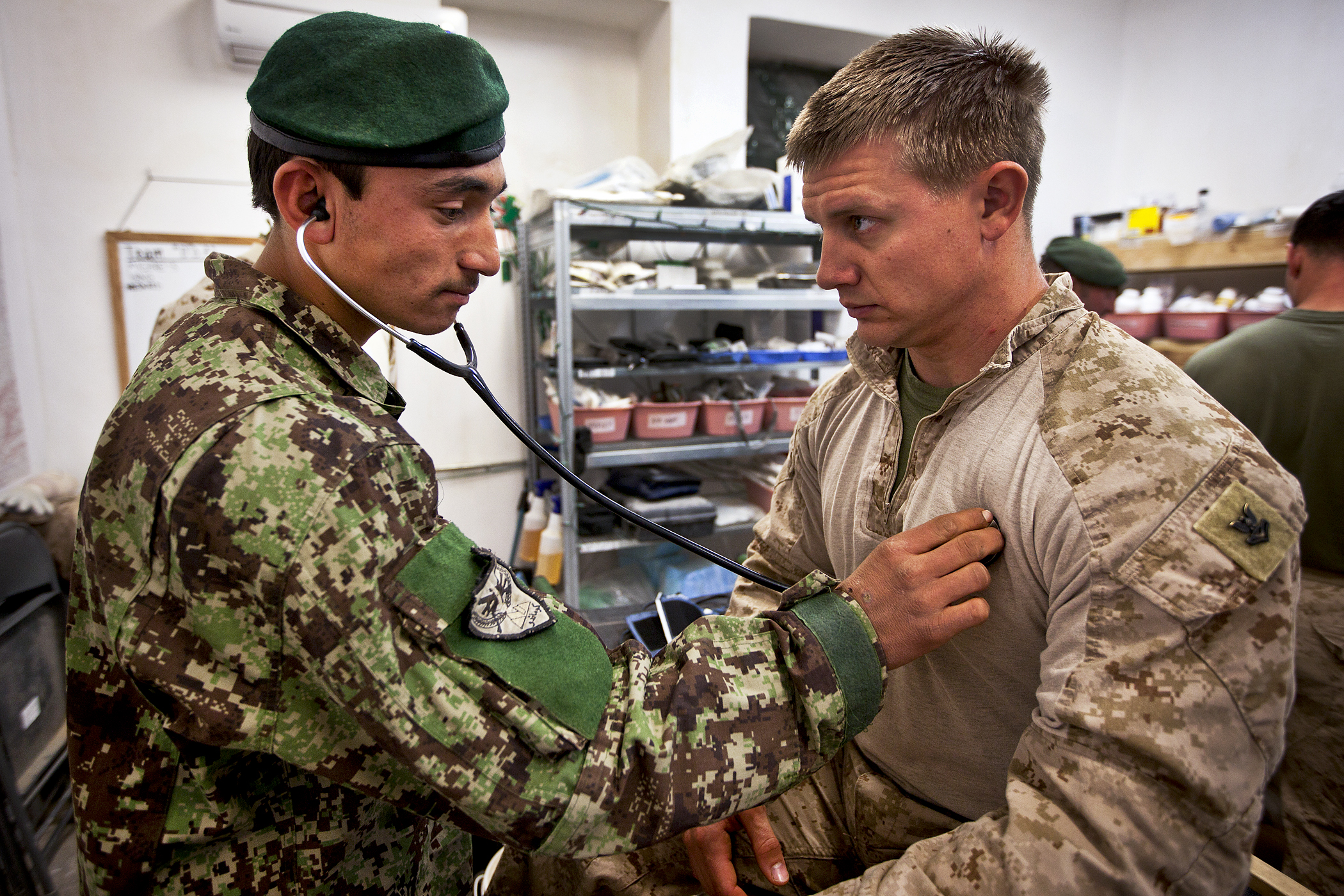 Afghan army Pvt. Samad Khan, a medic, checks the heartbeat of U.S. Navy ...