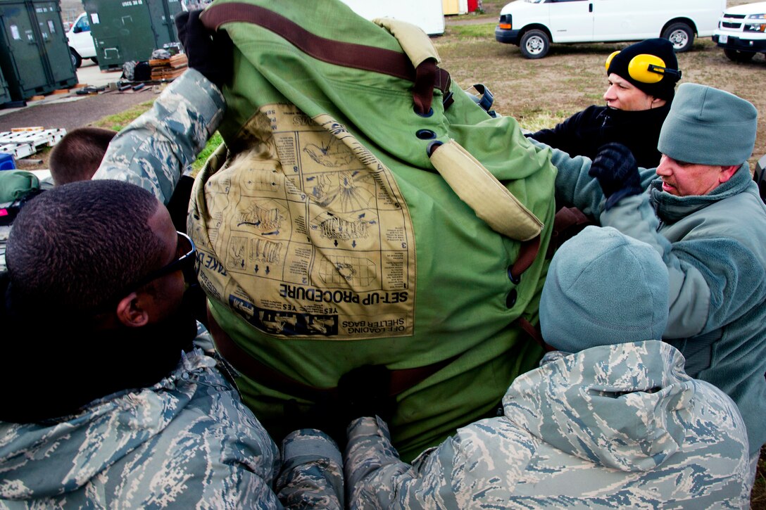 Air Force airmen collapse a field tent used for air control and flight ...
