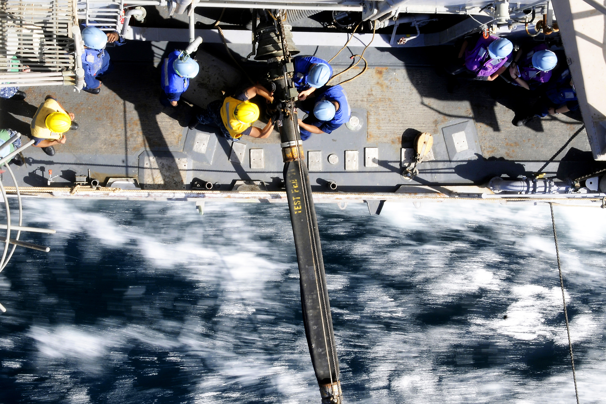 U.S. sailors tie down a refueling probe aboard the USS Bunker Hill ...