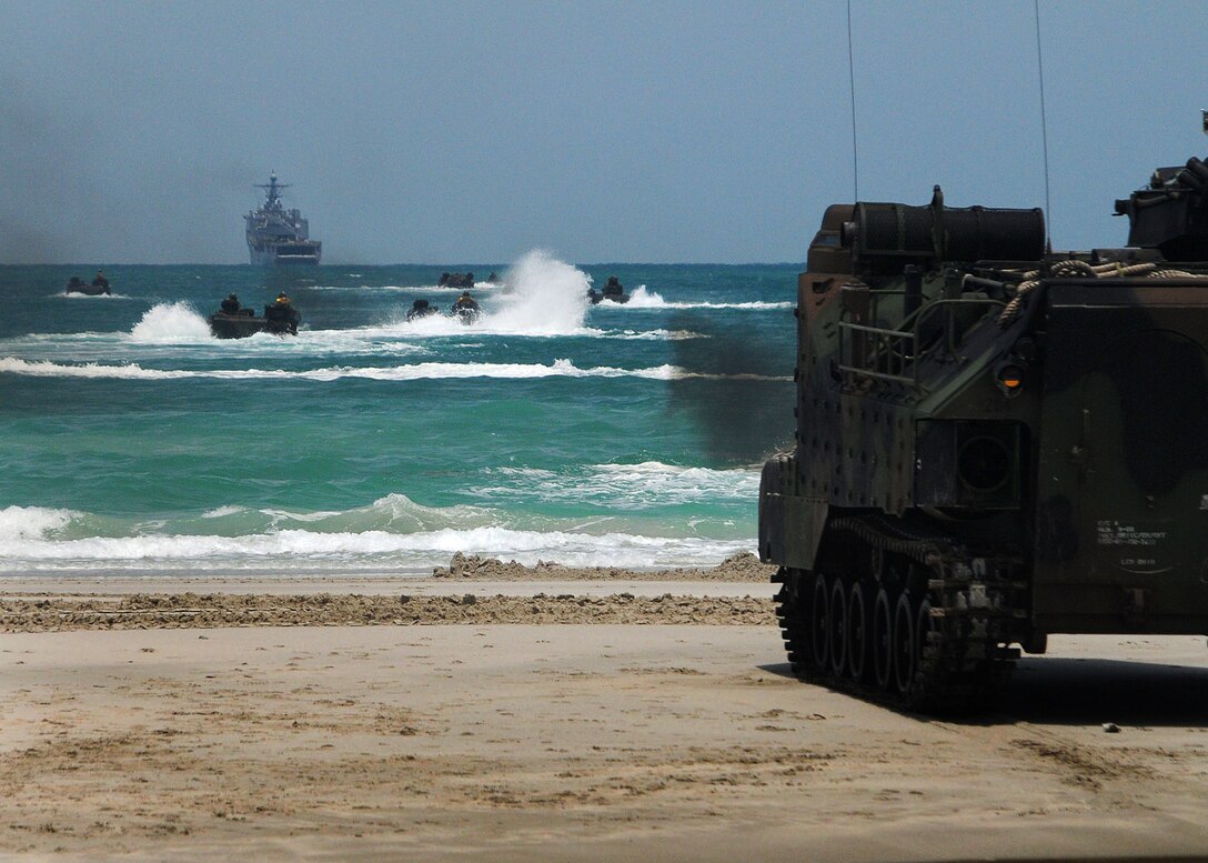 U.S. Marine amphibious assault vehicles depart the beach for the ...