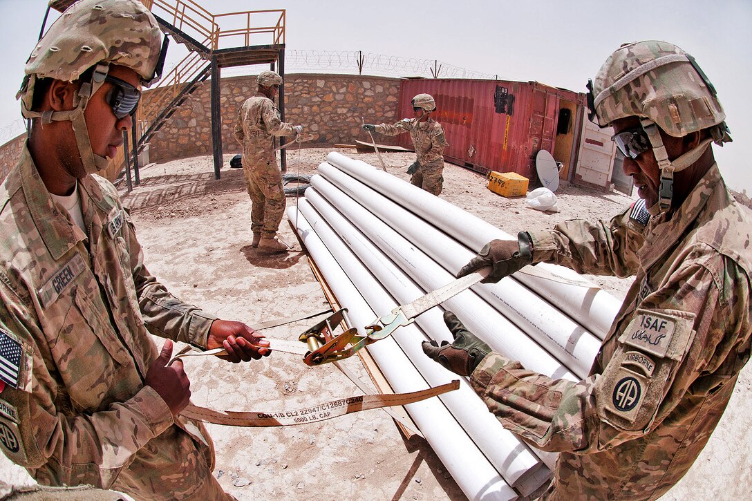U.S. Army Pvt. Rodrell Green, left, helps U.S. Army Sgt. Kenneth Jones ...