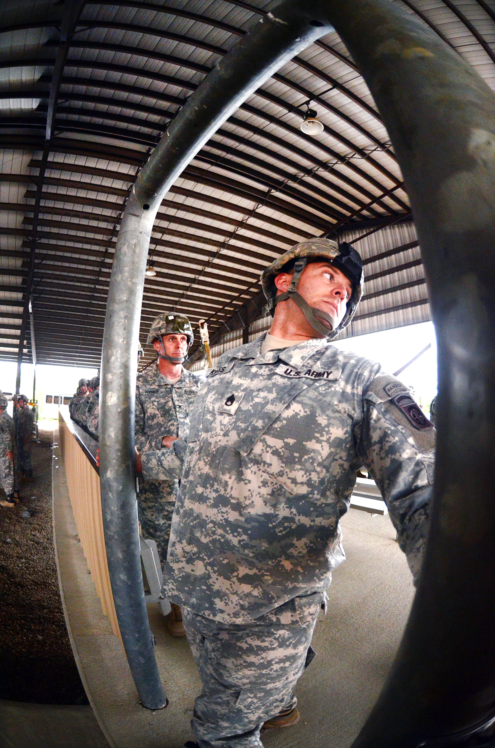 Army Col. Patrick Hynes, left, looks on as his primary jumpmaster ...