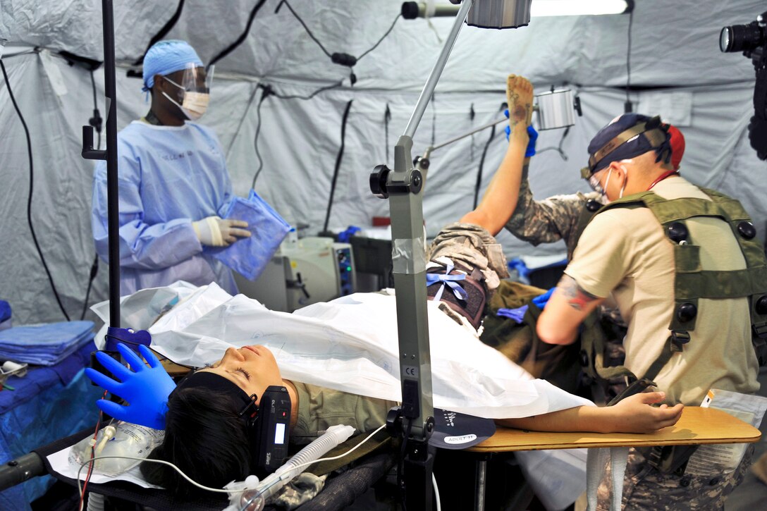 Soldiers prepare Air Force Staff Sgt. Vanessa Reed, a mock patient, for ...