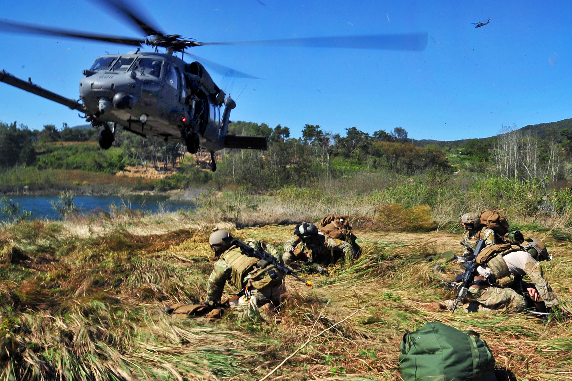 A U.S. Air Force combat rescue officer and three pararescuemen prepare ...