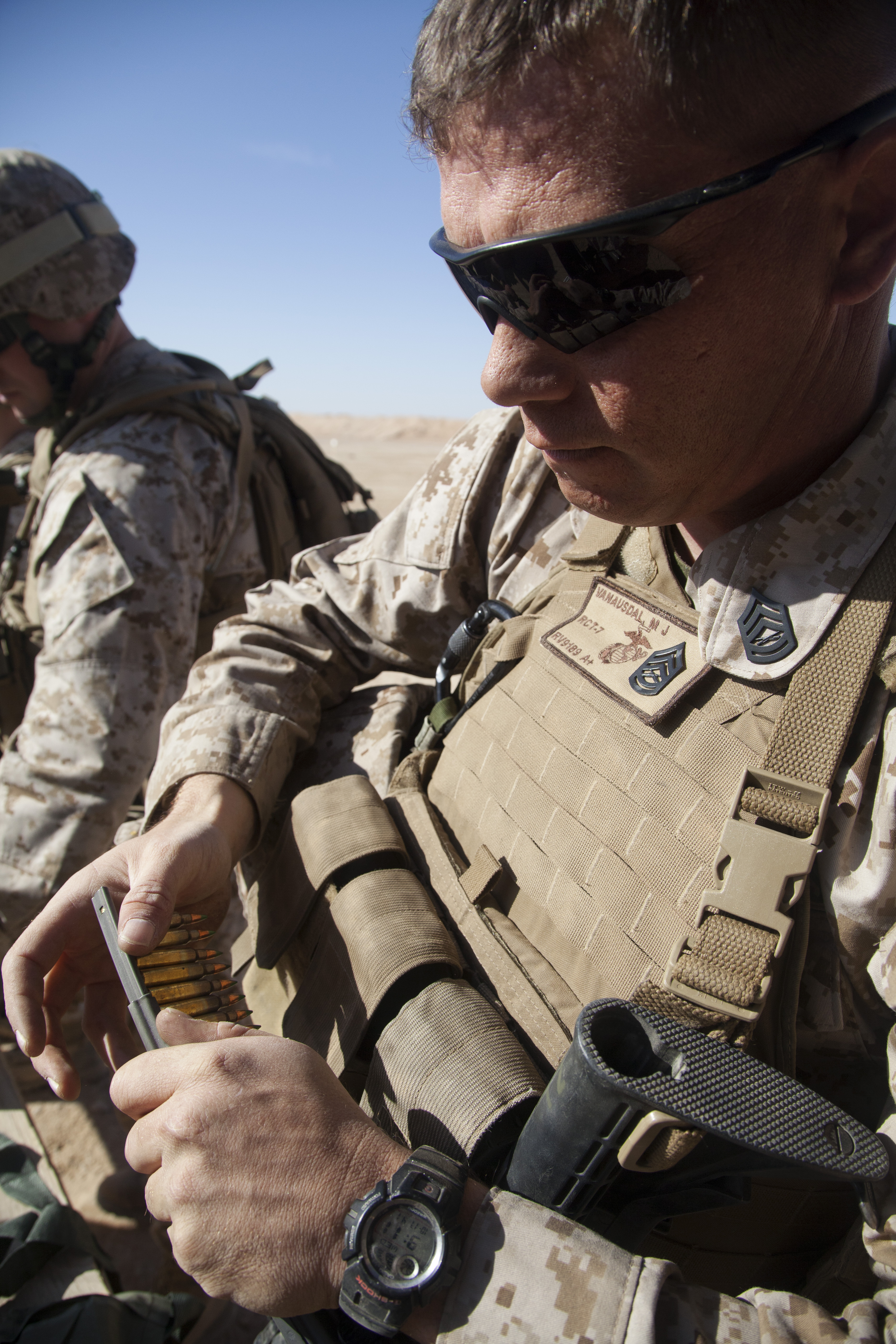 U.S. Marine Corps Gunnery Sgt. Max J. VanAusdal loads a magazine at a ...