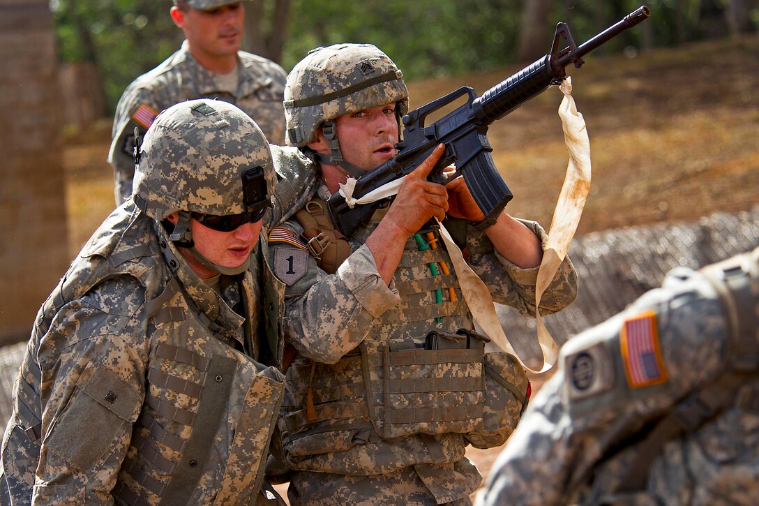 Army Sgt. Justin Runyan, right, assists simulated casualties to a ...