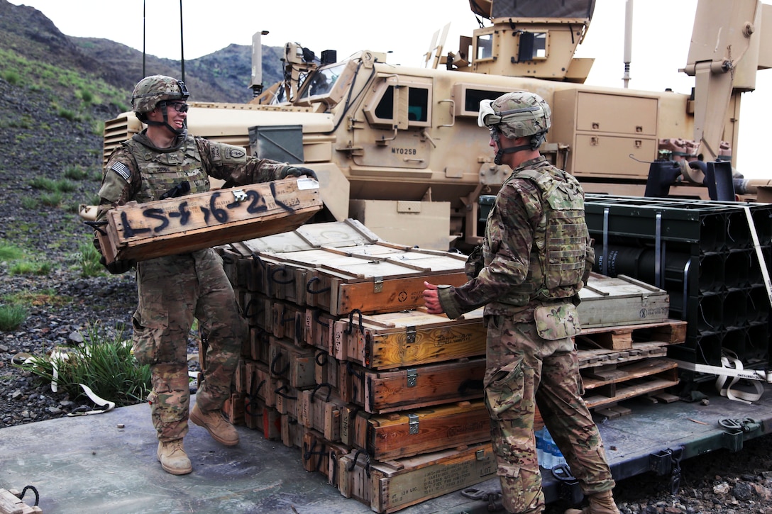 U.S. soldiers load empty ordinance boxes onto a truck at the demolition ...