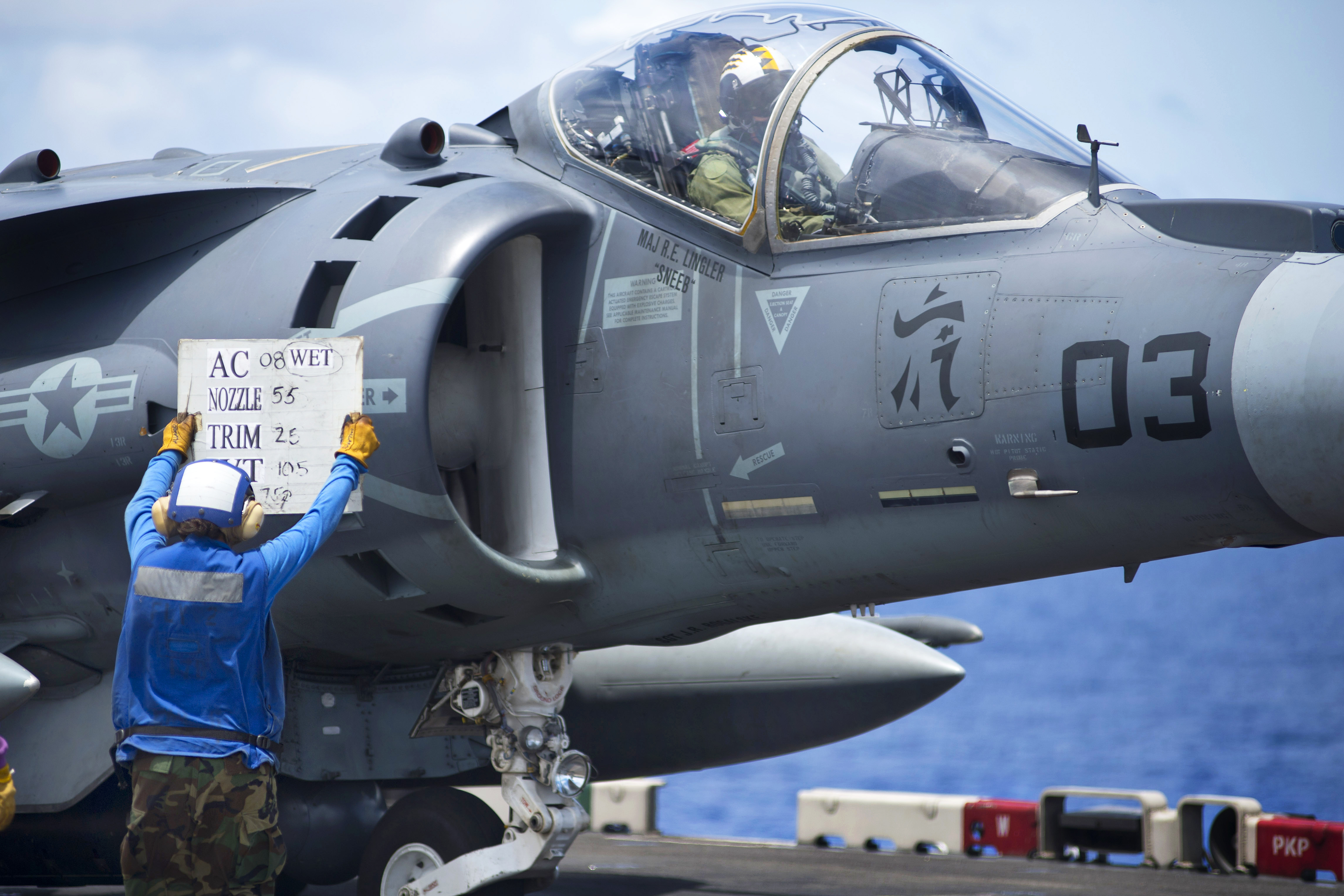 U.S. Navy Seaman Dania Gallardo holds up a tote board to communicate ...