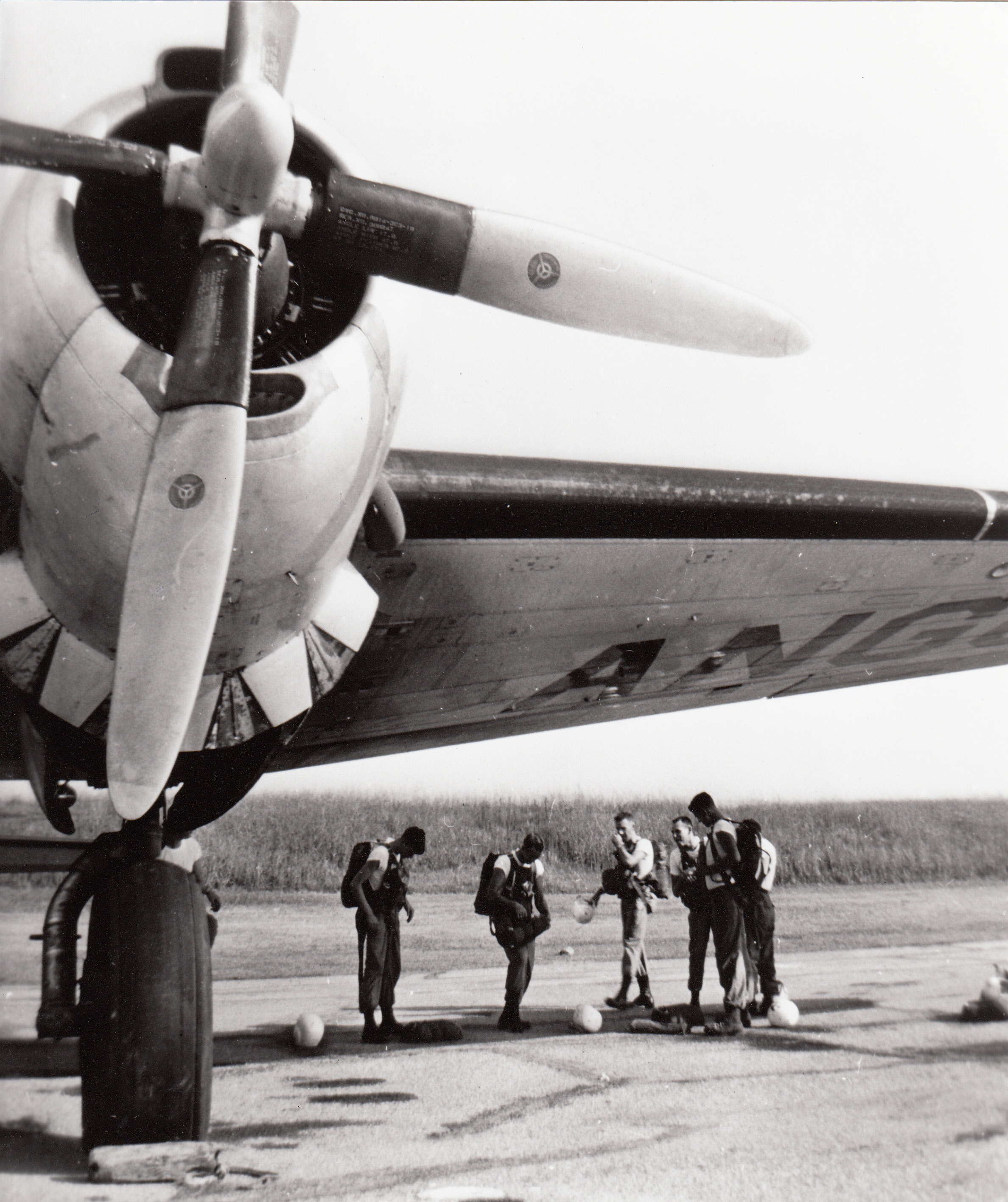 Army paratroopers don their parachutes by a C-47 of the 135th Air ...