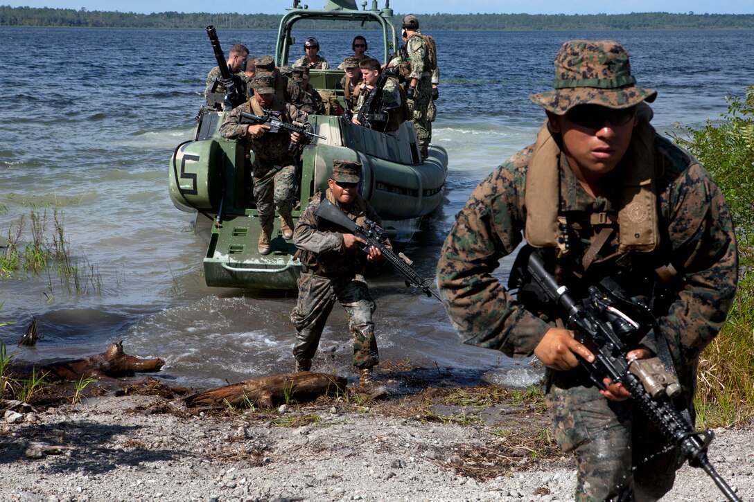 U.S. Marines and sailors insert into a landing zone as part of a ...