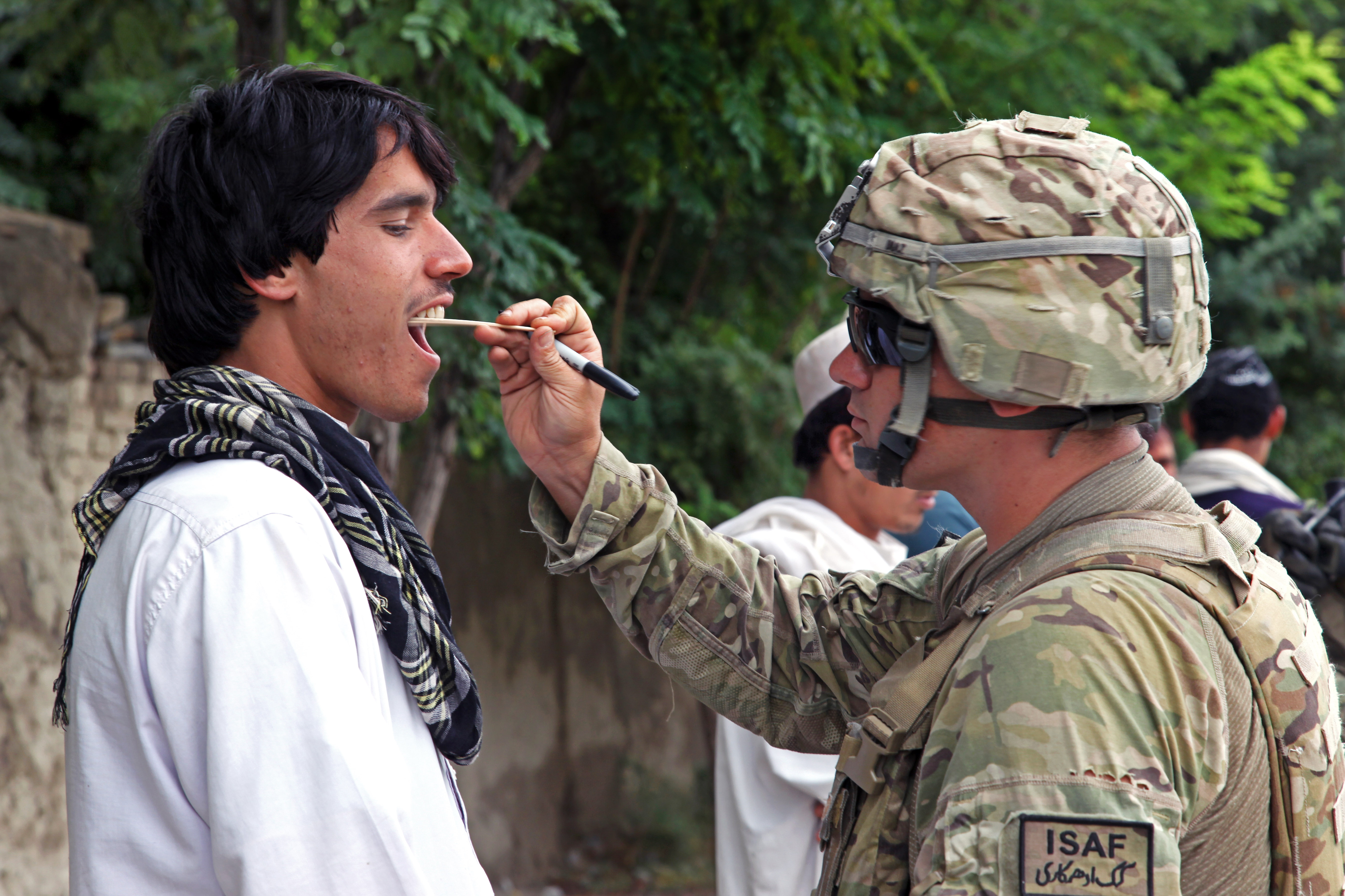 U.S. Army Pfc. David Diaz, right, collects a DNA sample for biometrics ...
