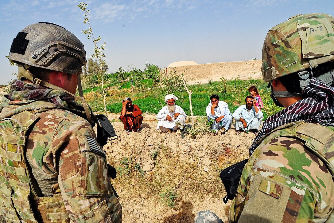 U.S. Army Capt. Erik Hickly, left, discusses road conditions with ...