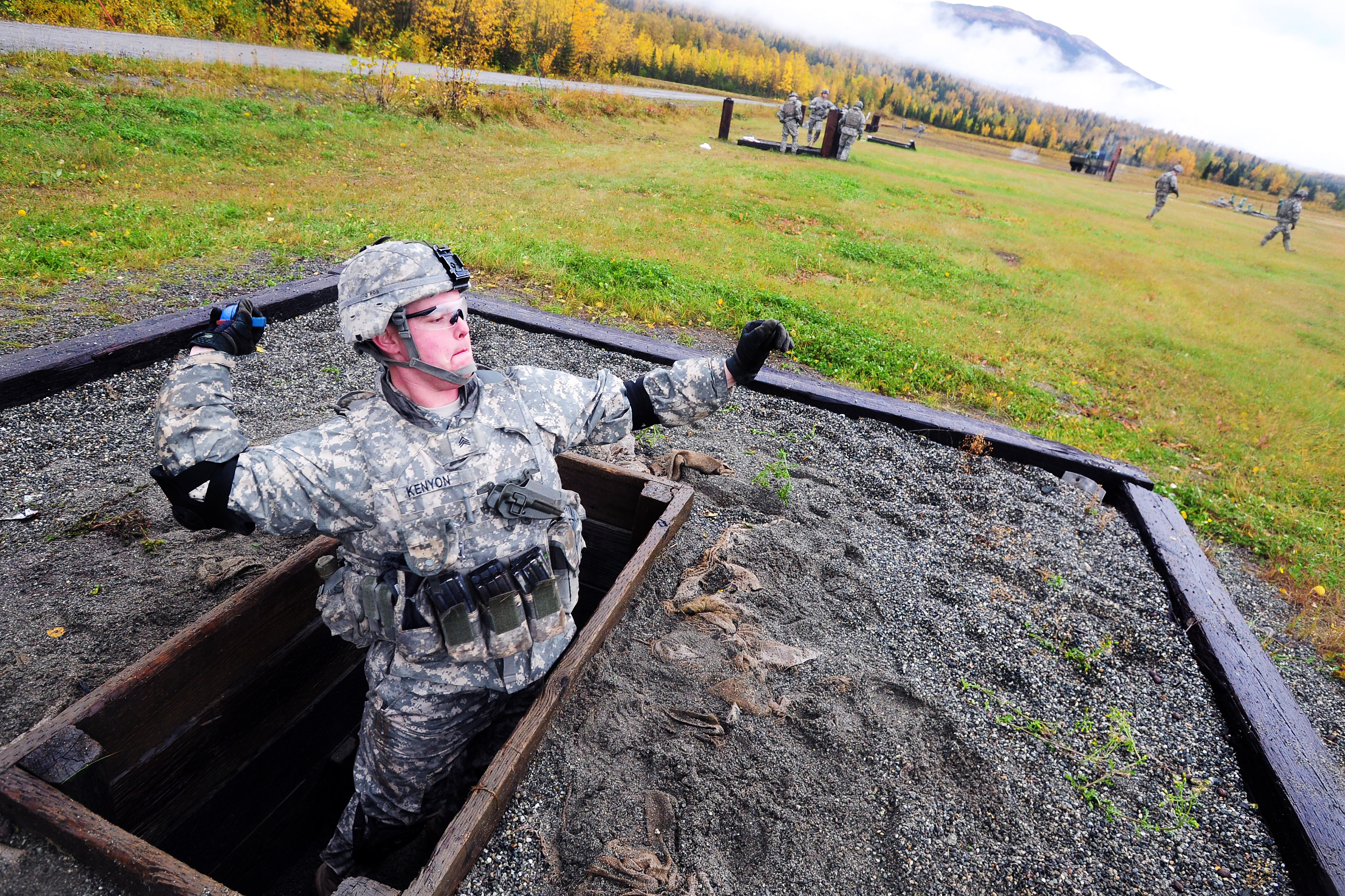 Army Sgt. Westley Kenyon throws a practice hand grenade from a foxhole ...