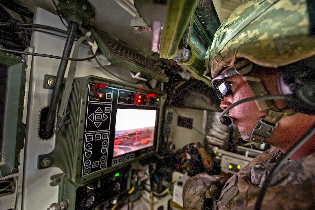 U.S. Army Spc. Warren Feeley looks through a fire control system inside ...