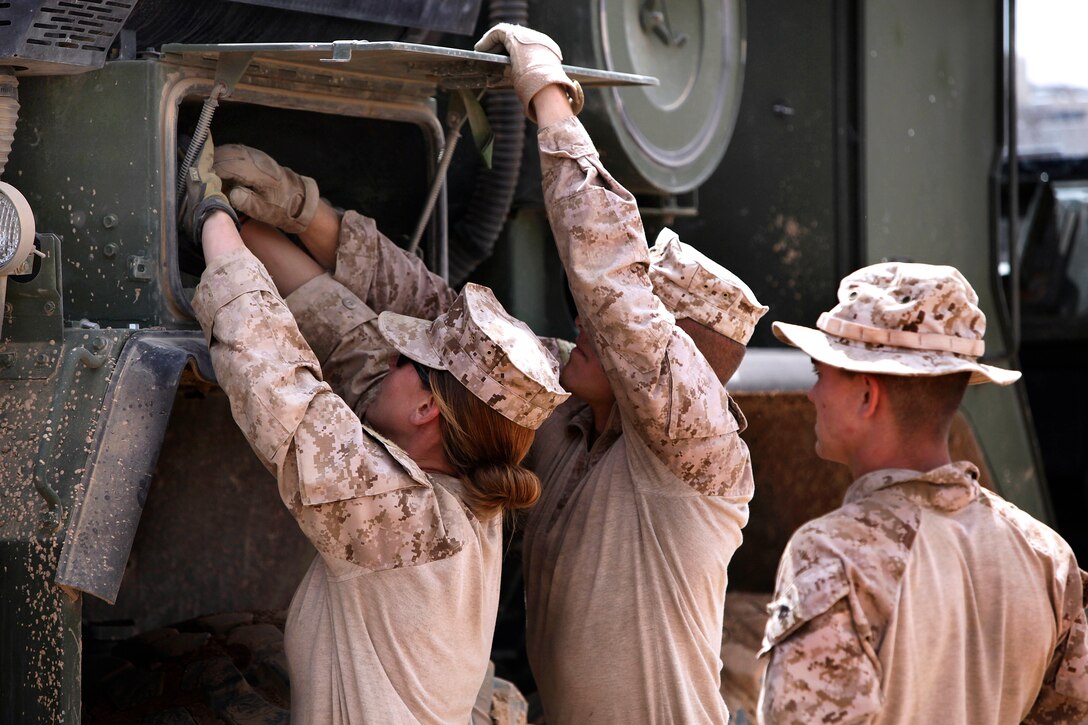 U.S. Marines pack up chains after off-loading a Volvo 30k front loader ...