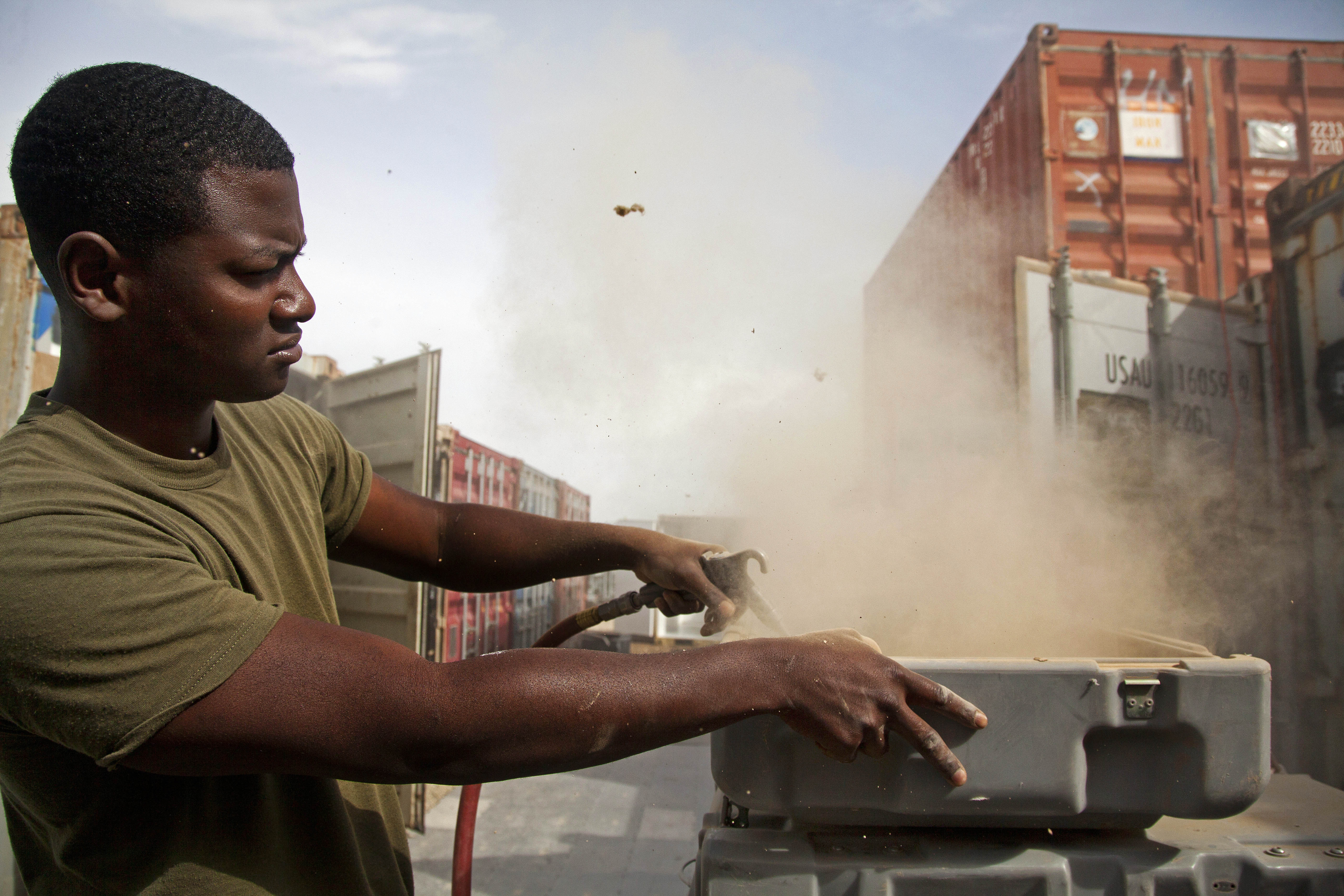 U.S. Marine Corps Lance Cpl. Jermaine Pullum cleans communication ...