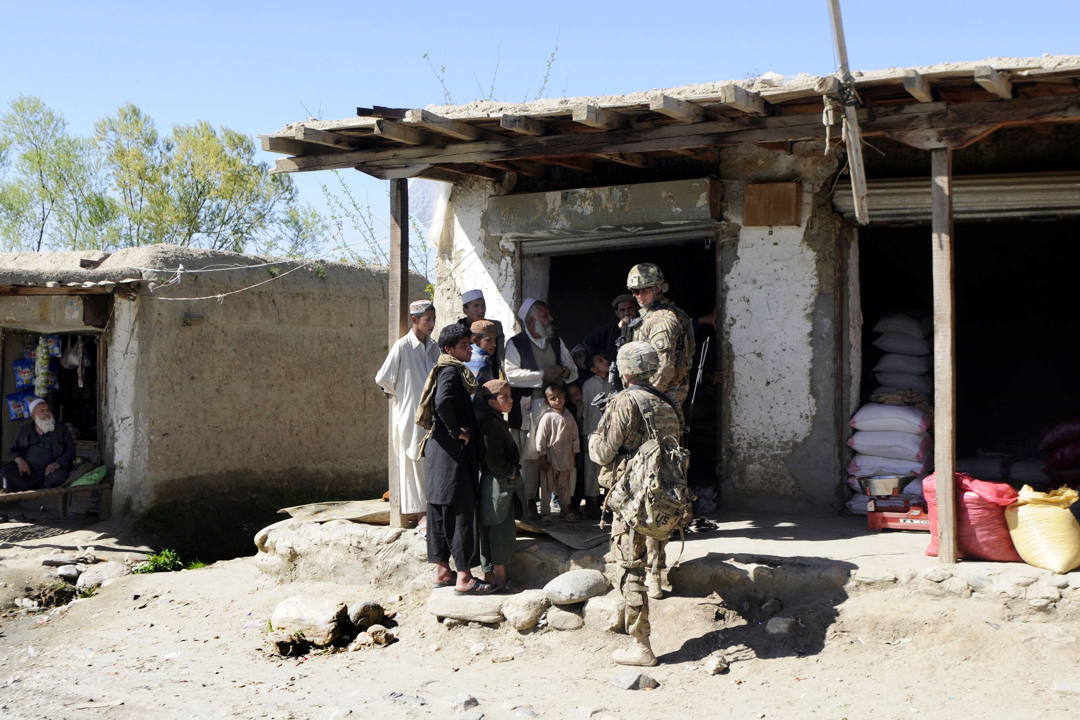 U.S. soldiers talk to Afghan villagers and shopkeepers at a bazaar in ...