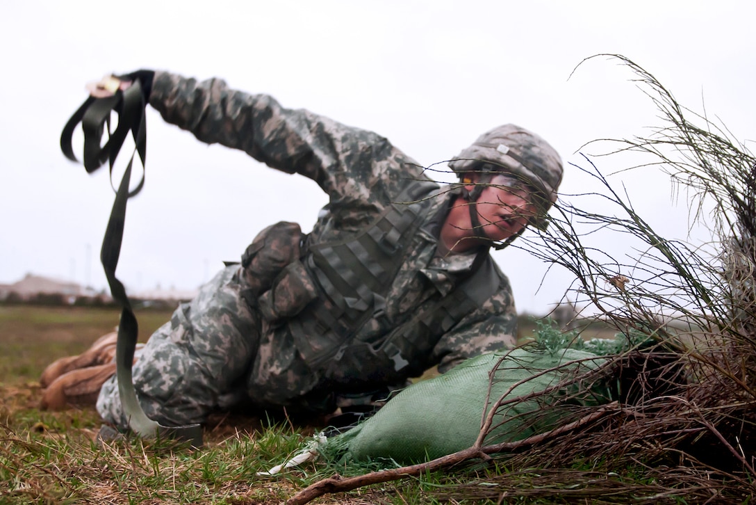 Army Pfc. Steven Williams throws a grappling hook to check for booby ...