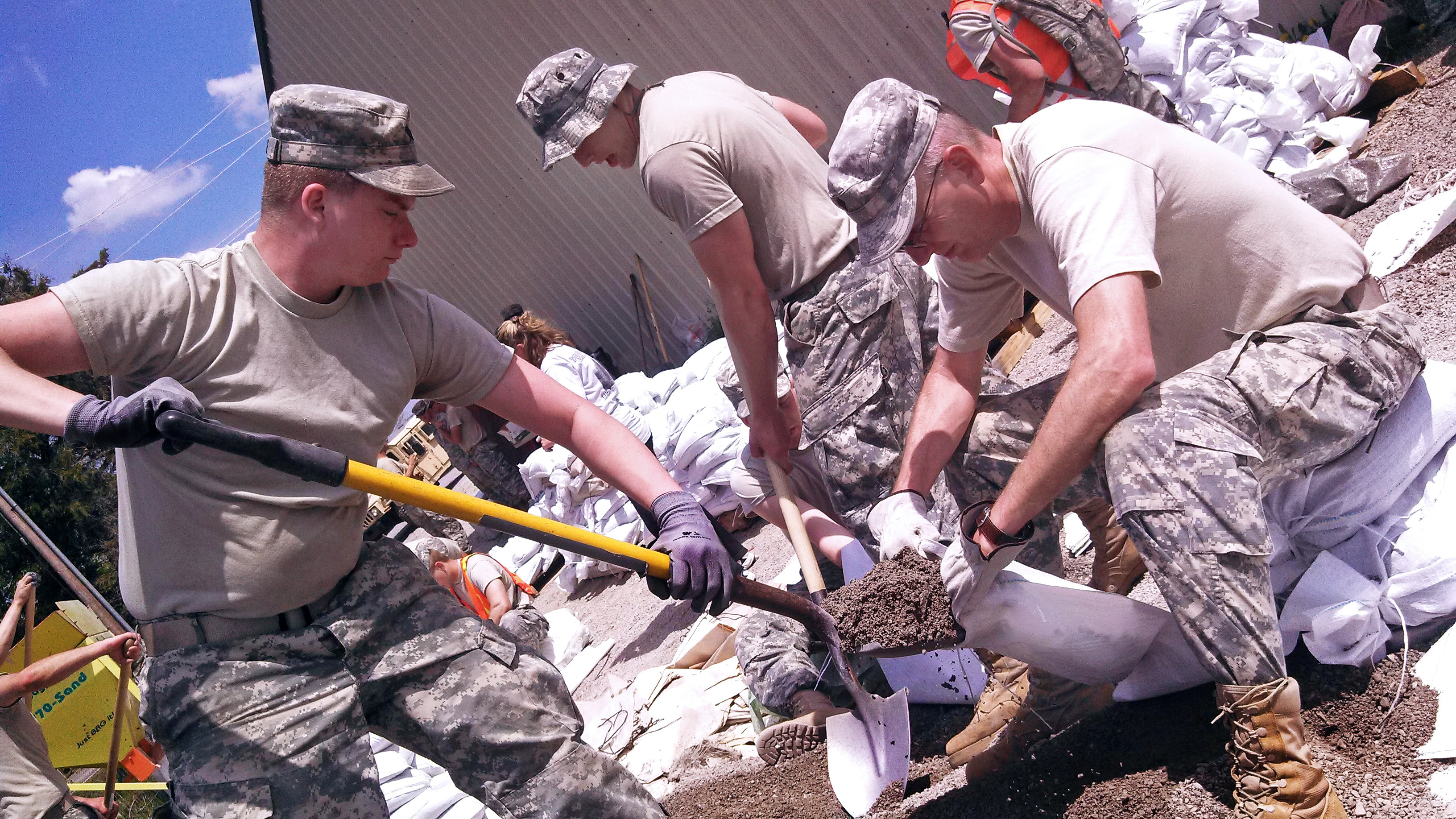 Army Spcs. Charles Friedrich and Brandon Birge fill sandbags during ...