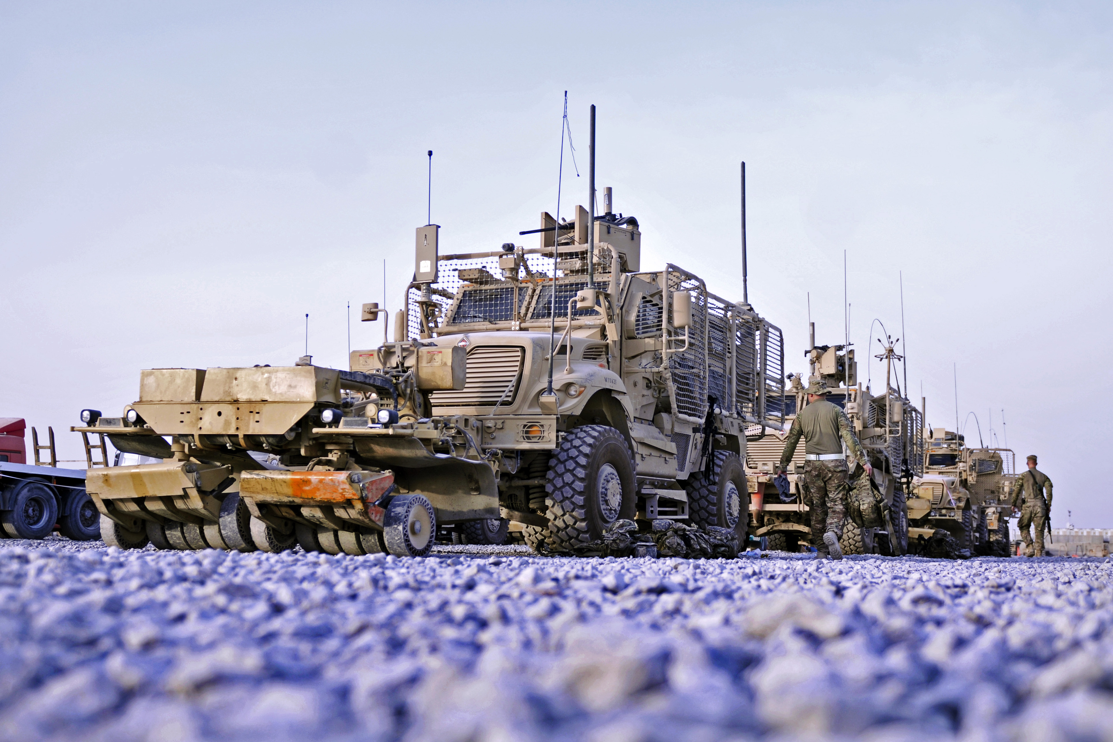 U.S. Army troops conduct safety checks and mount weapons on trucks ...