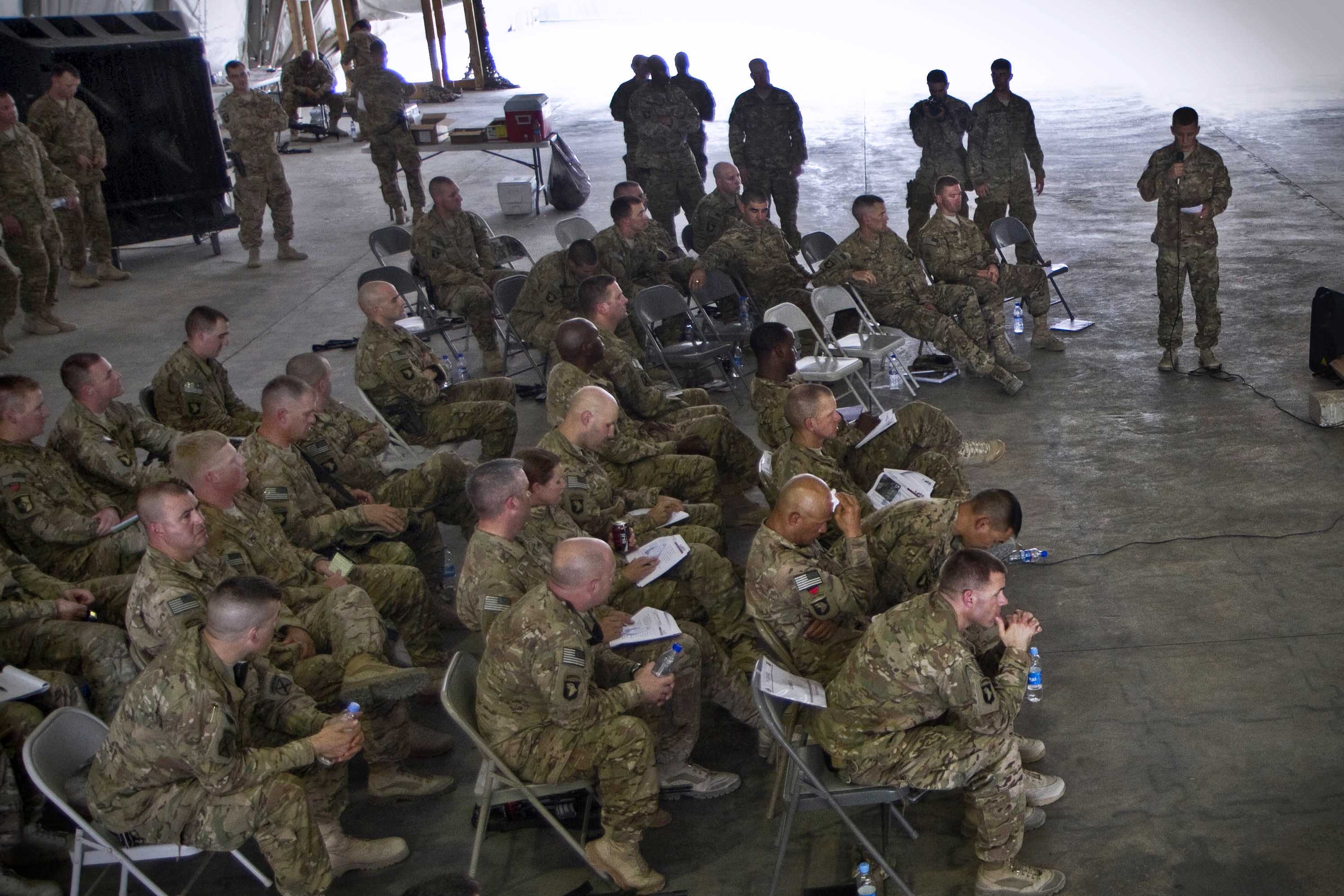 U.S. Army officers and noncommissioned officers listen to a briefing ...