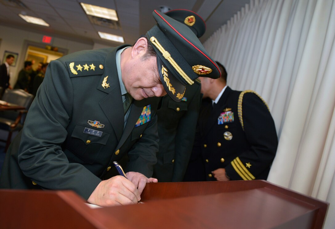 Chinese Defense Minister Gen. Chang Wanquan signs the guestbook as he ...