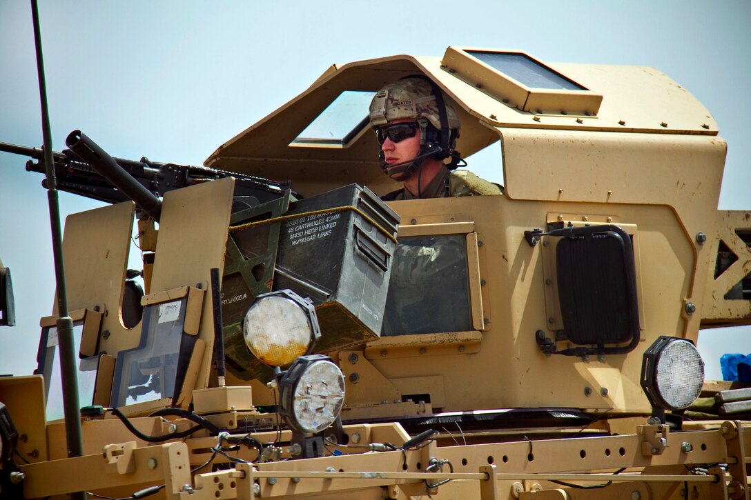U.S. Army Spc. Shane T. Coates provides security as he mans his machine ...