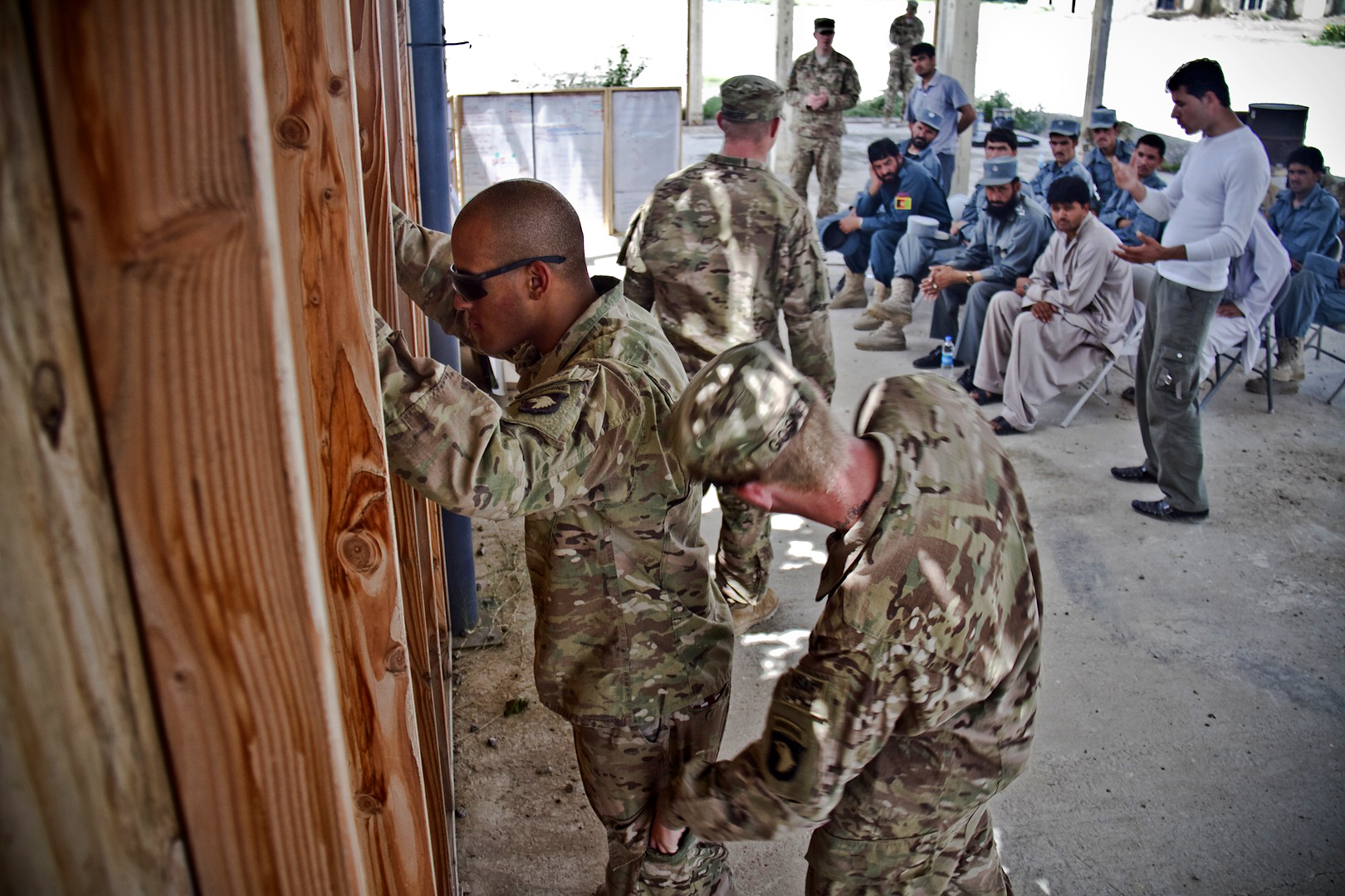U.S. Army Spcs. David J. Gosney, left, searches Mathew W. Harrold ...