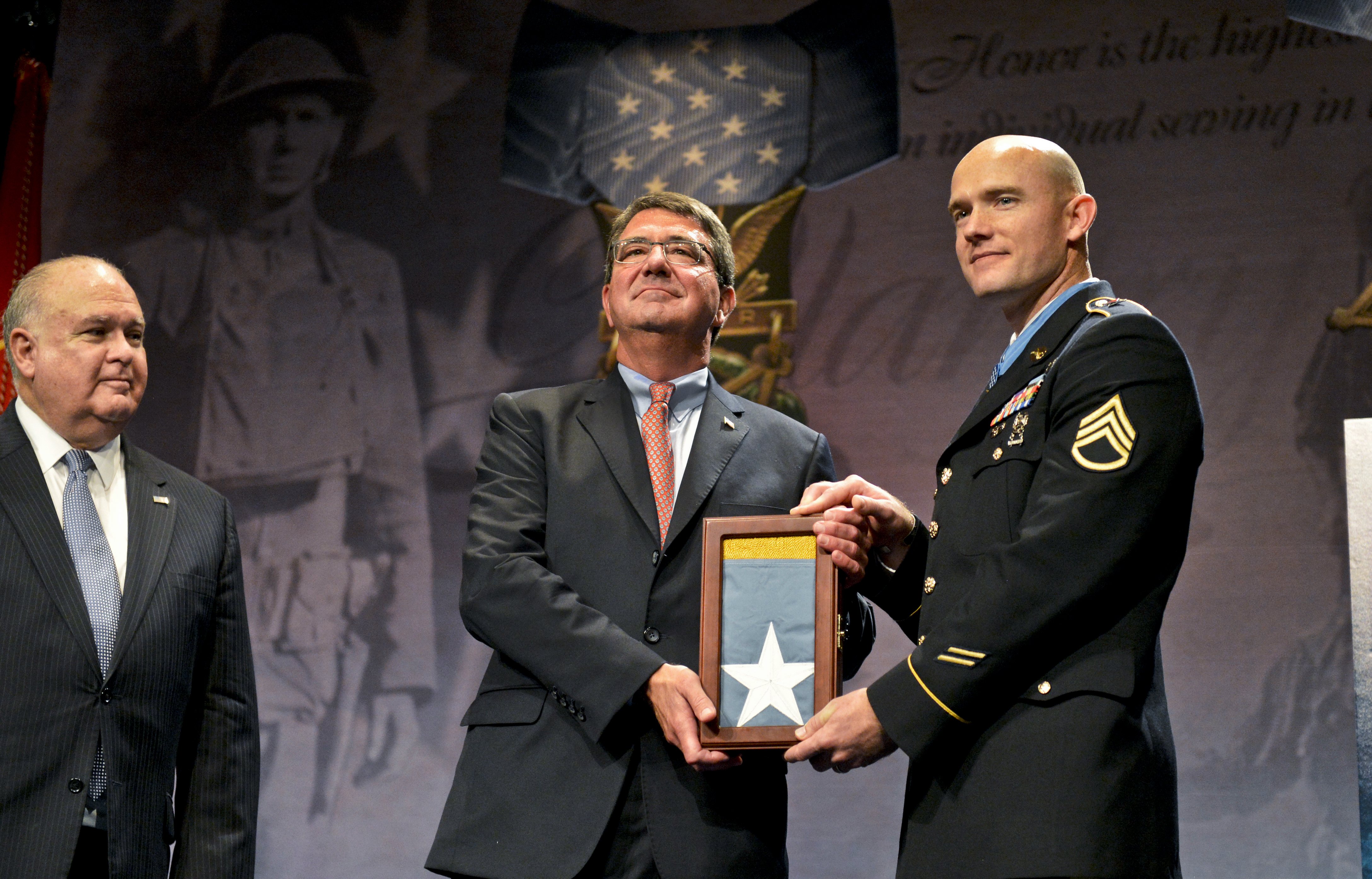 Deputy Defense Secretary Ash Carter presents the Medal of Honor Flag to Medal of Honor recipient ...