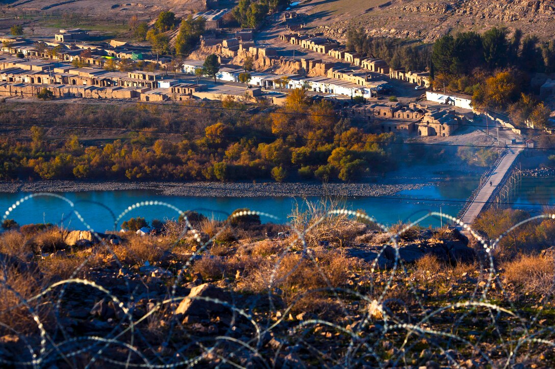 The bridge and bazaar in the village of Kajaki sit beneath a ...