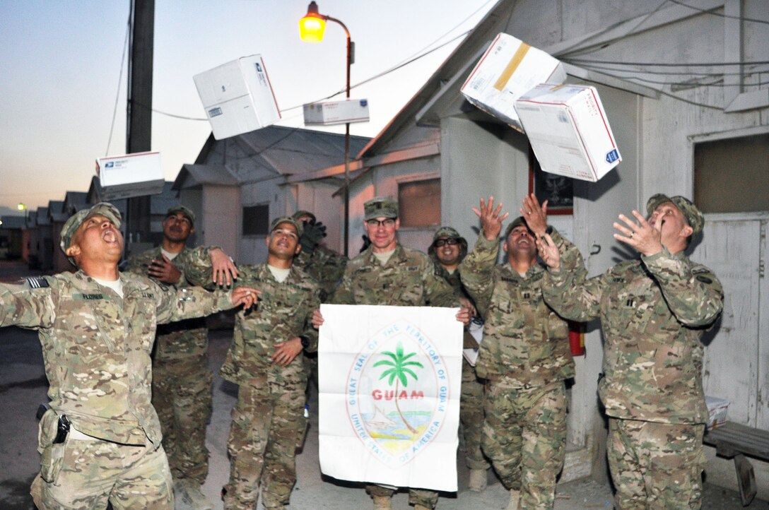 U.S. soldiers toss their care packages into the air on Camp Phoenix in ...