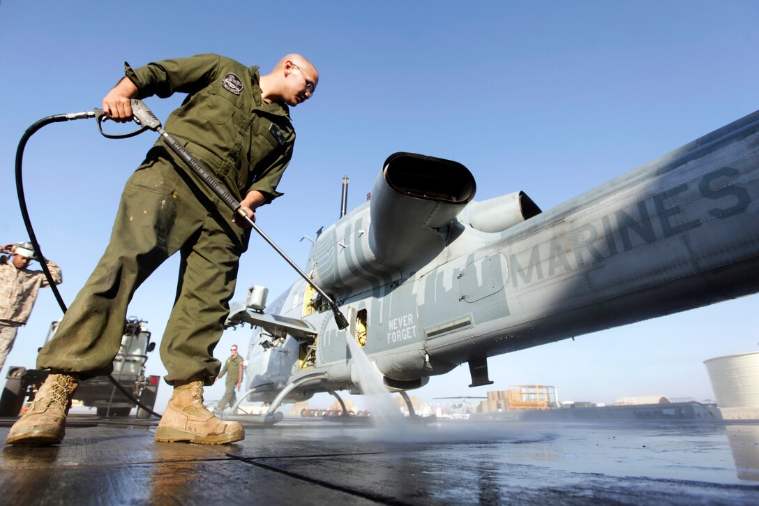 U.S. Marine Corps Lance Cpl. Alexander Rangel washes the side of a UH ...
