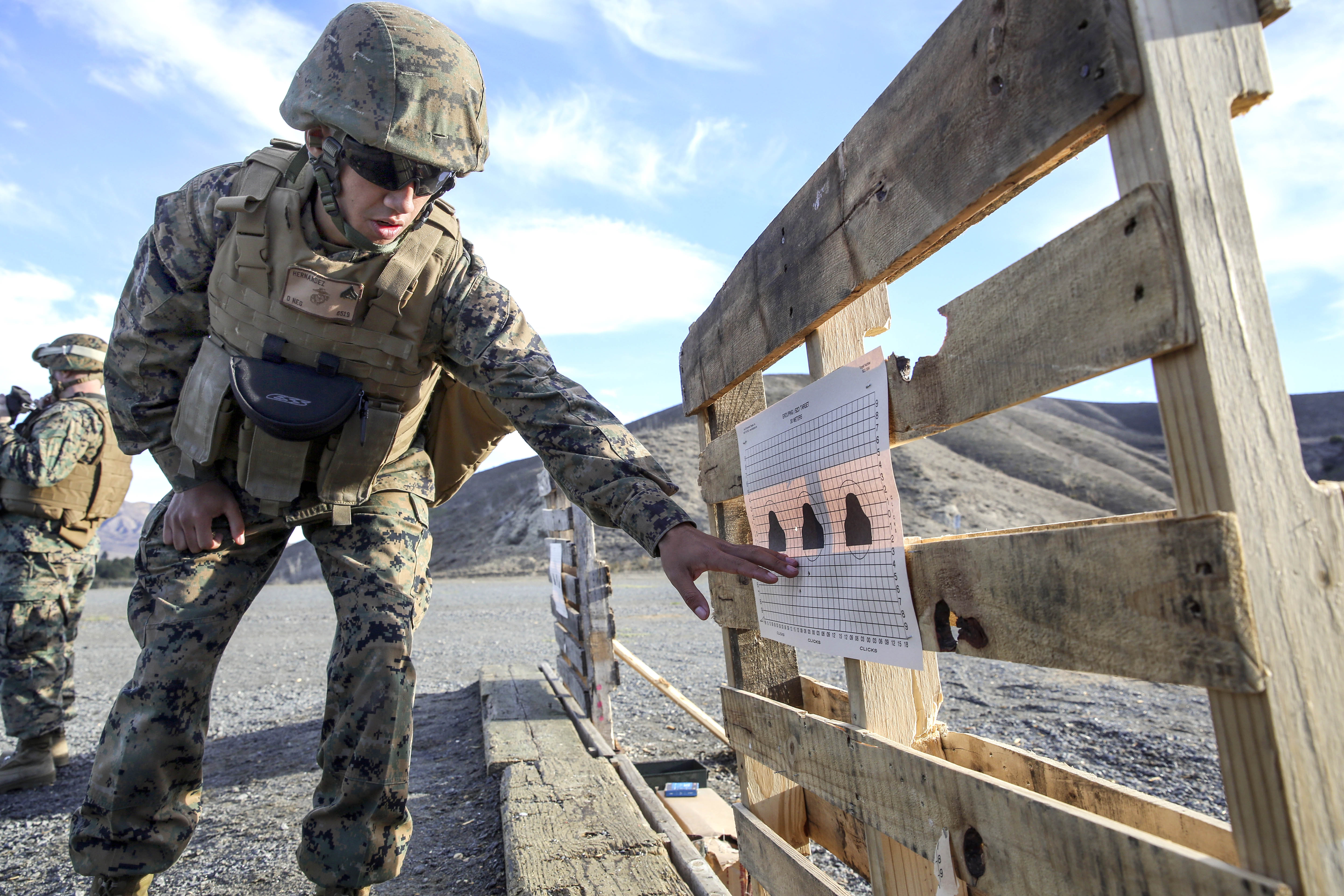 Marine Corps Cpl. Richard Hernandez makes calculations to a target to ...
