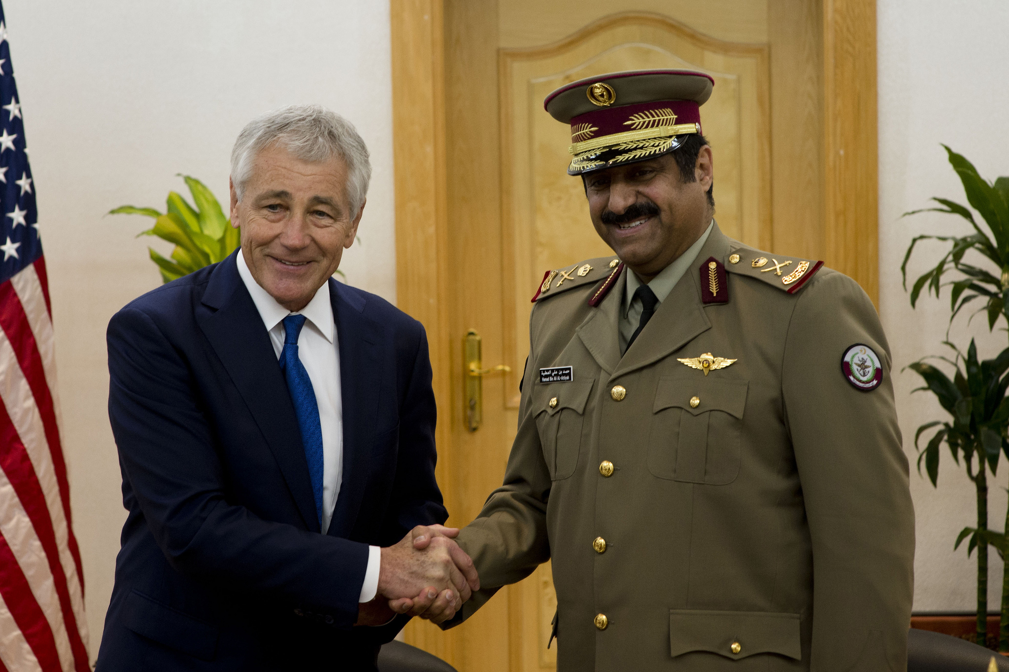 U.S. Defense Secretary Chuck Hagel, left, shakes hands with Qatari Maj ...