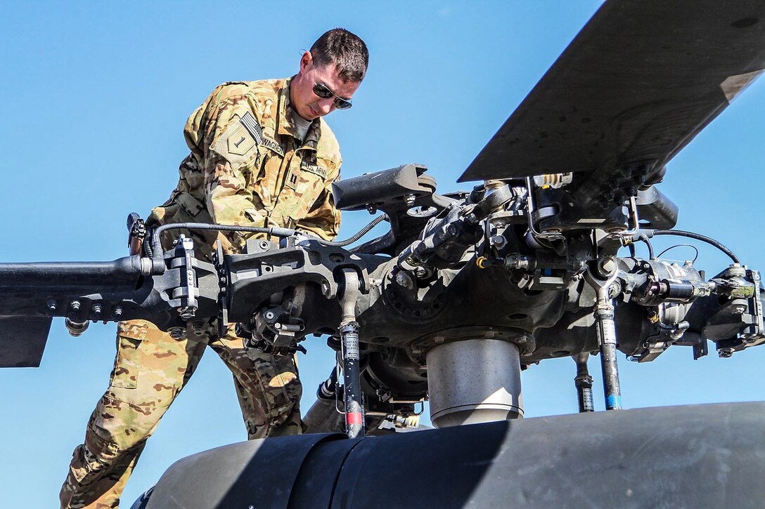 U.S. Army Capt. Andrew Wagner inspects the blades on a U.S. Army UH-60 ...