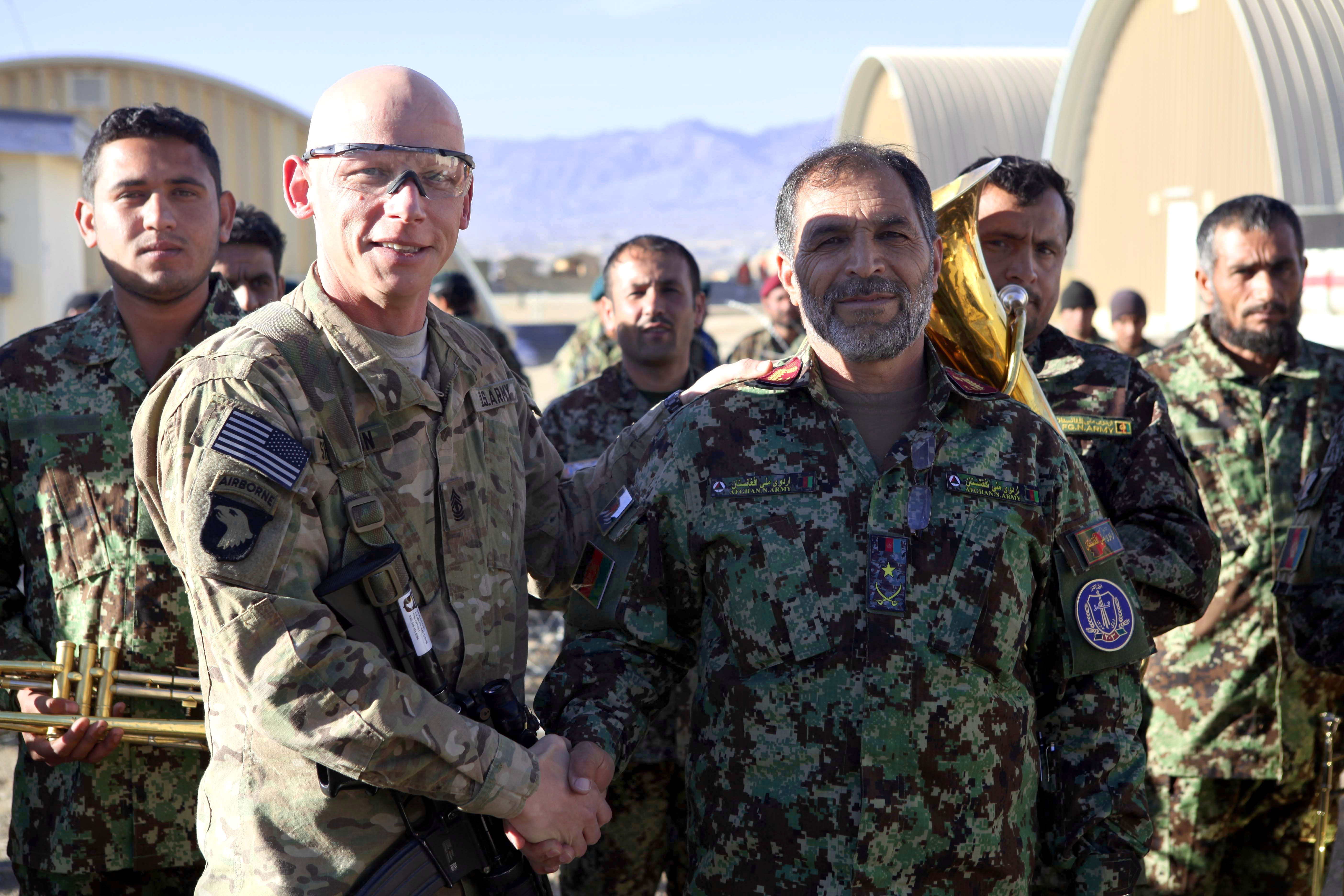 U.S. Army 1st Sgt. Daniel Shannon, left, shakes hands with Afghan army ...