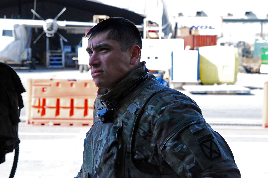 U.S. Army Sgt. 1st Class Aaron Perez puts on his body armor before ...