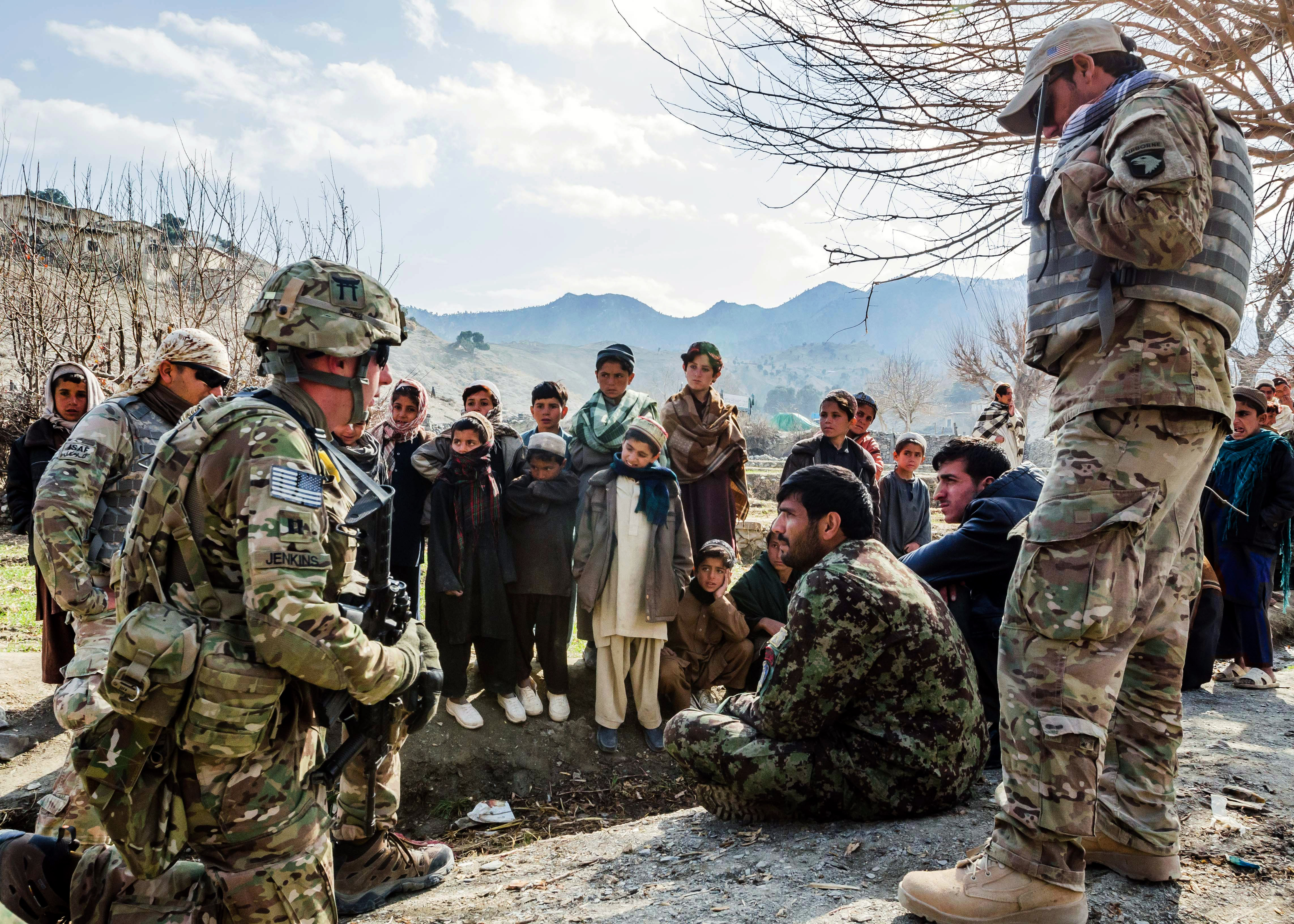 Afghan children gather to watch as U.S. Army Capt. Andrew Jenkins, left ...