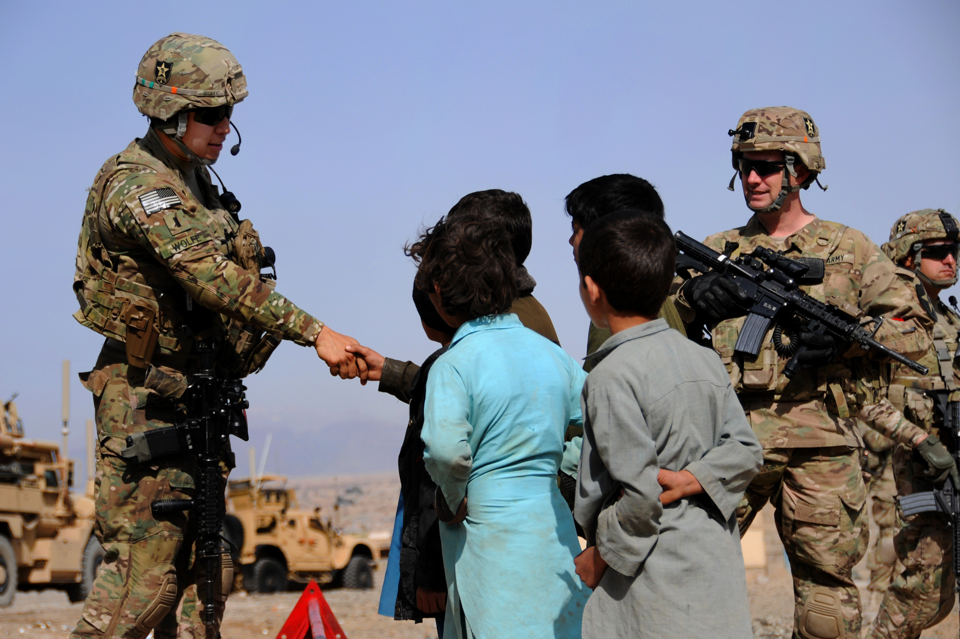 U.S. Army 1st Lt. Robert Wolfe, left, shakes hands with a young Afghan ...