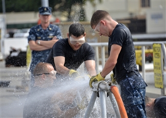 Submariners patch a simulated damaged pipe during a damage control ...
