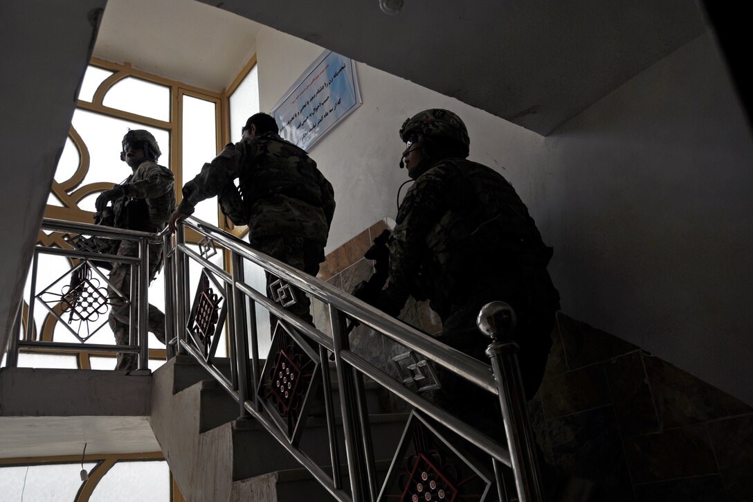 U.S. tropps clear a stairwell before a meeting in Farah City ...